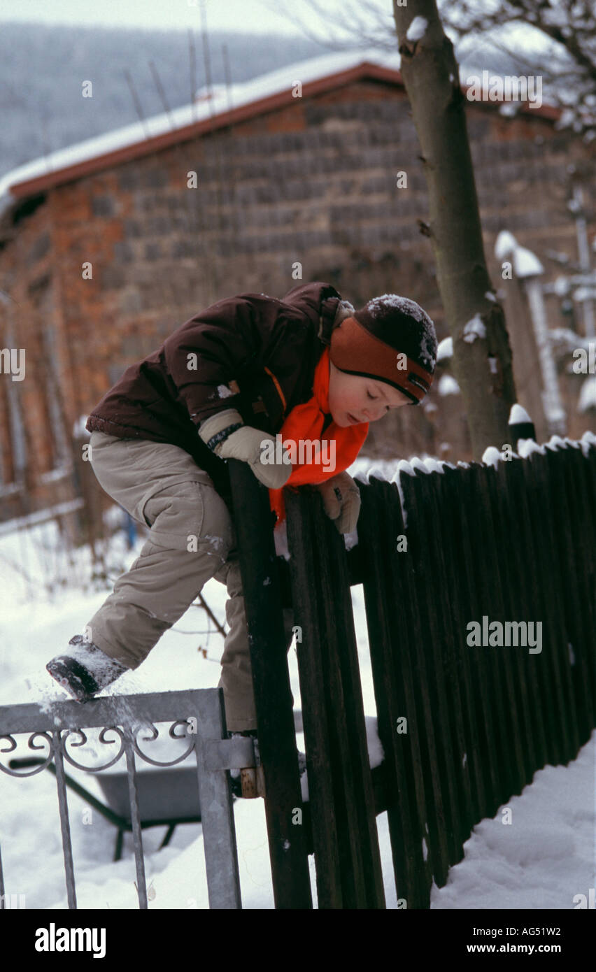 Boy climbing over a fence Stock Photo - Alamy