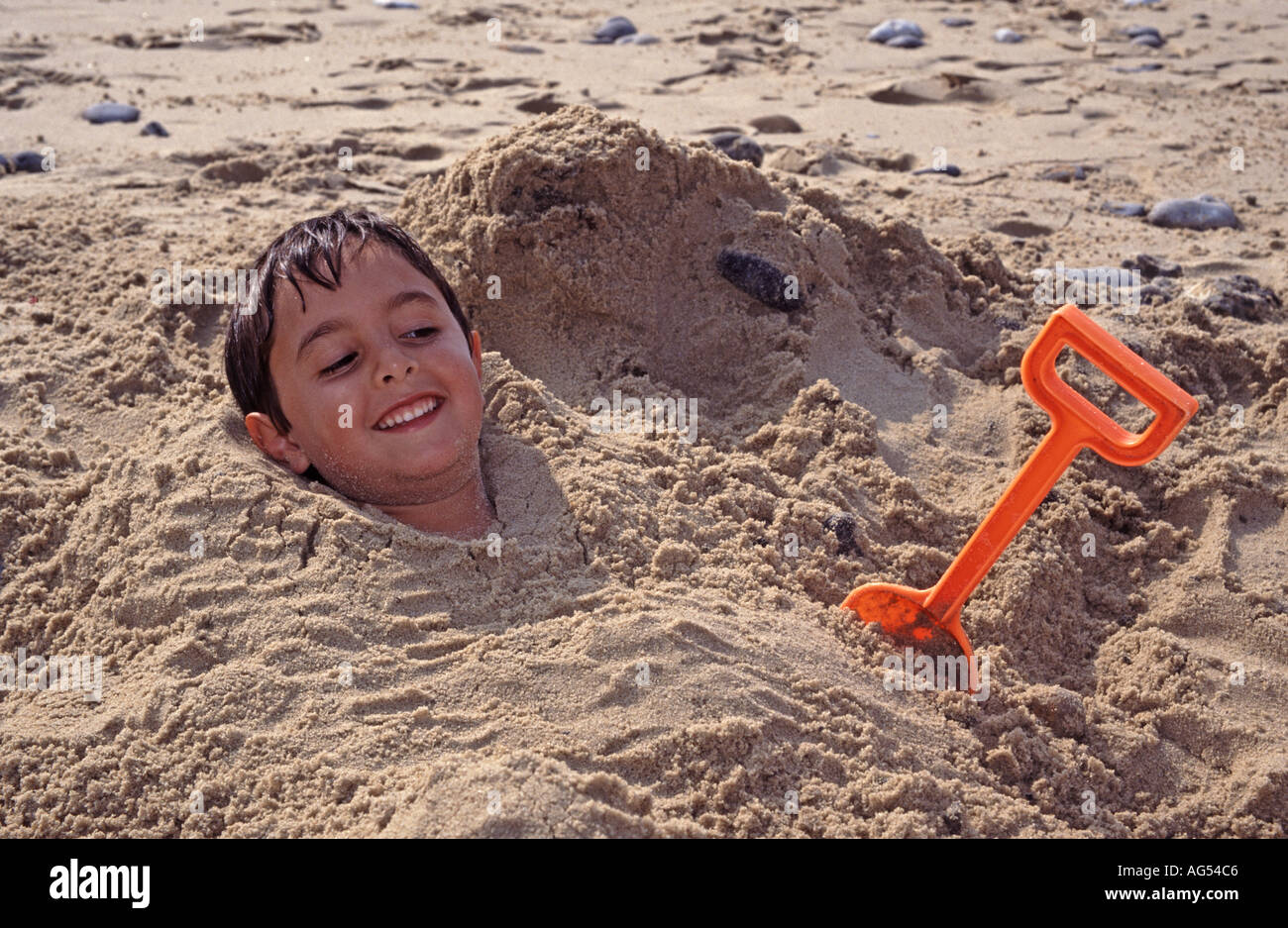 Boy Buried in Sand on Beach Stock Photo - Alamy