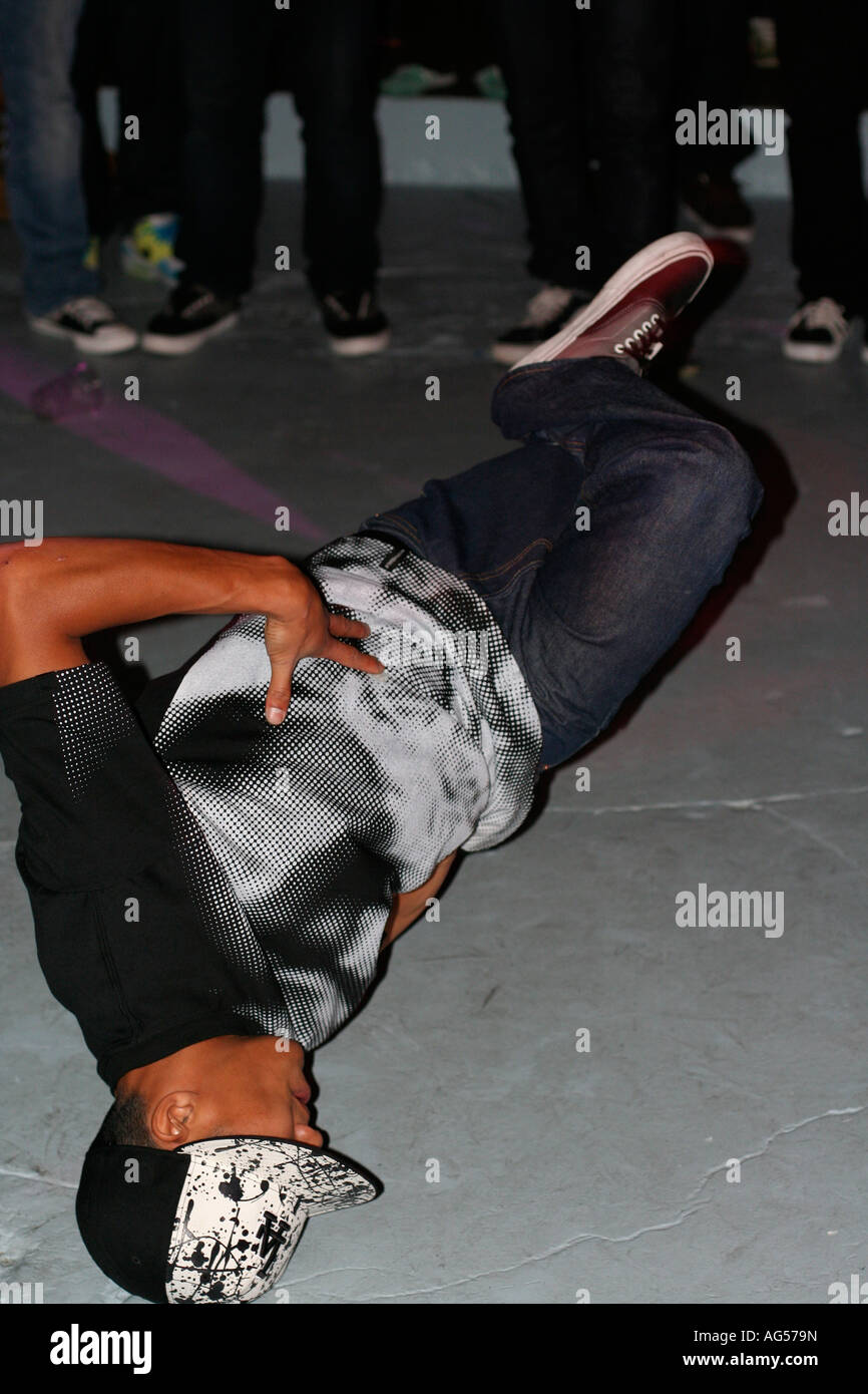 A dancer contorted in a complex move on the ground with legs and shoes ...