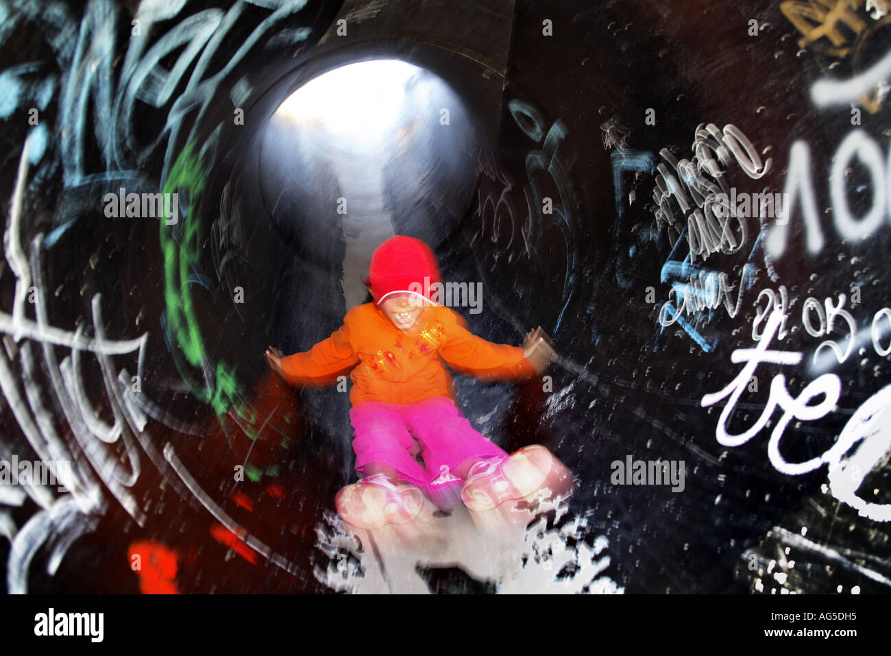 young girl sliding down a pipe Stock Photo - Alamy