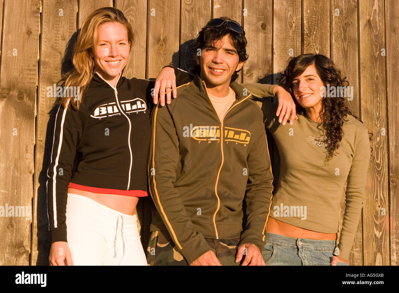 Friends chating and having fun with wood fence background Stock Photo ...