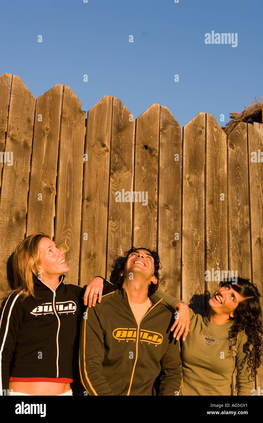 Friends chating and having fun with wood fence background Stock Photo ...