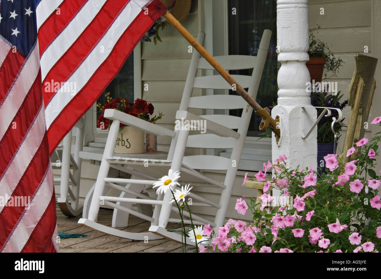 American Flag and Rocking Chair on Porch of Victorian Cottage with ...