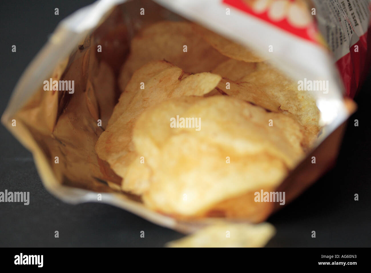 Close up of open packet of crisps / chips on black background Stock ...