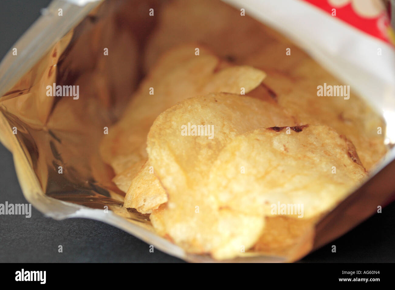 Close up of open packet of crisps / chips on black background Stock ...