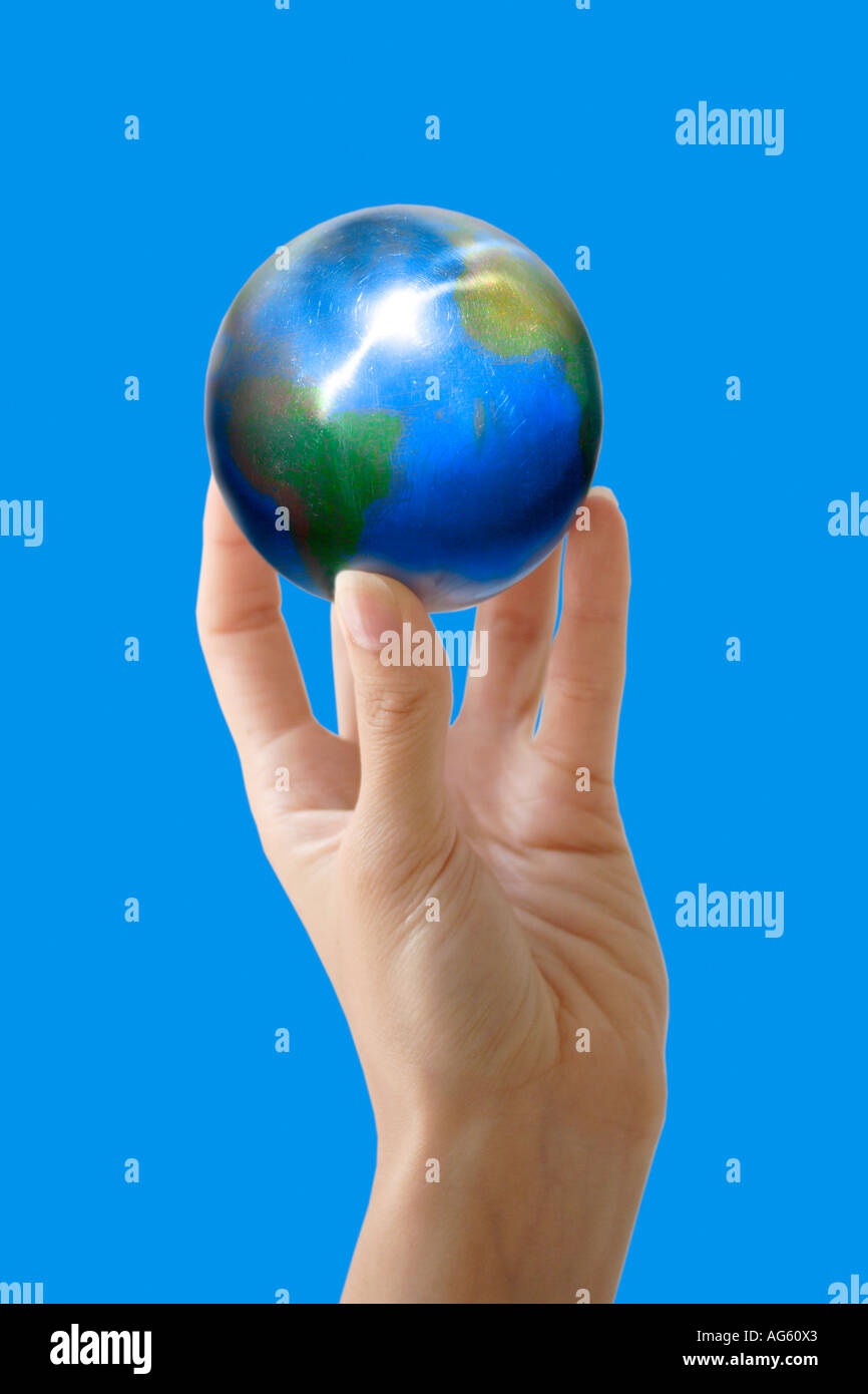 world balanced on fingertips in front of blue background Stock Photo ...