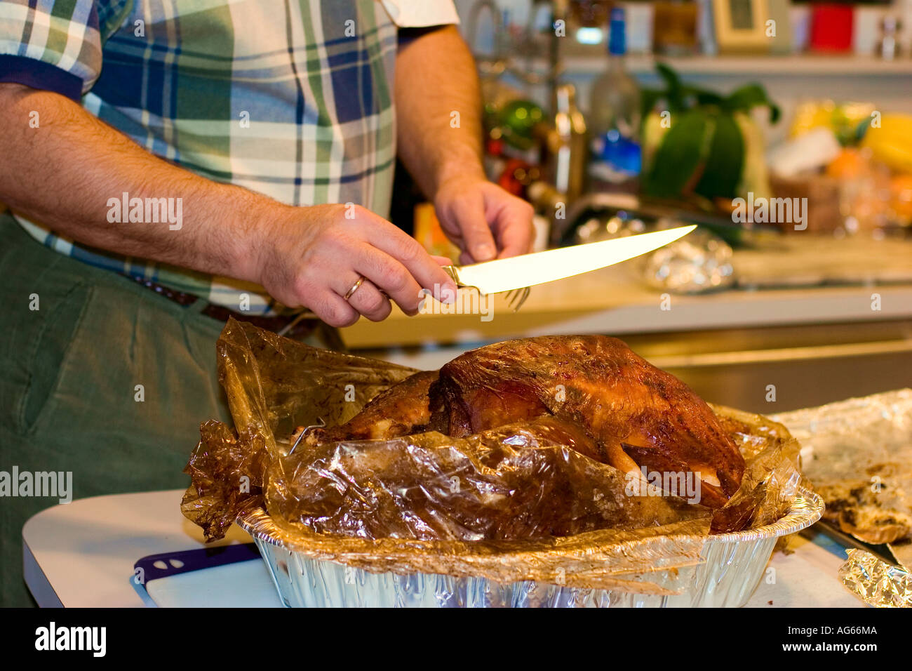 Man's hand cutting cooked turkey with knife Stock Photo - Alamy