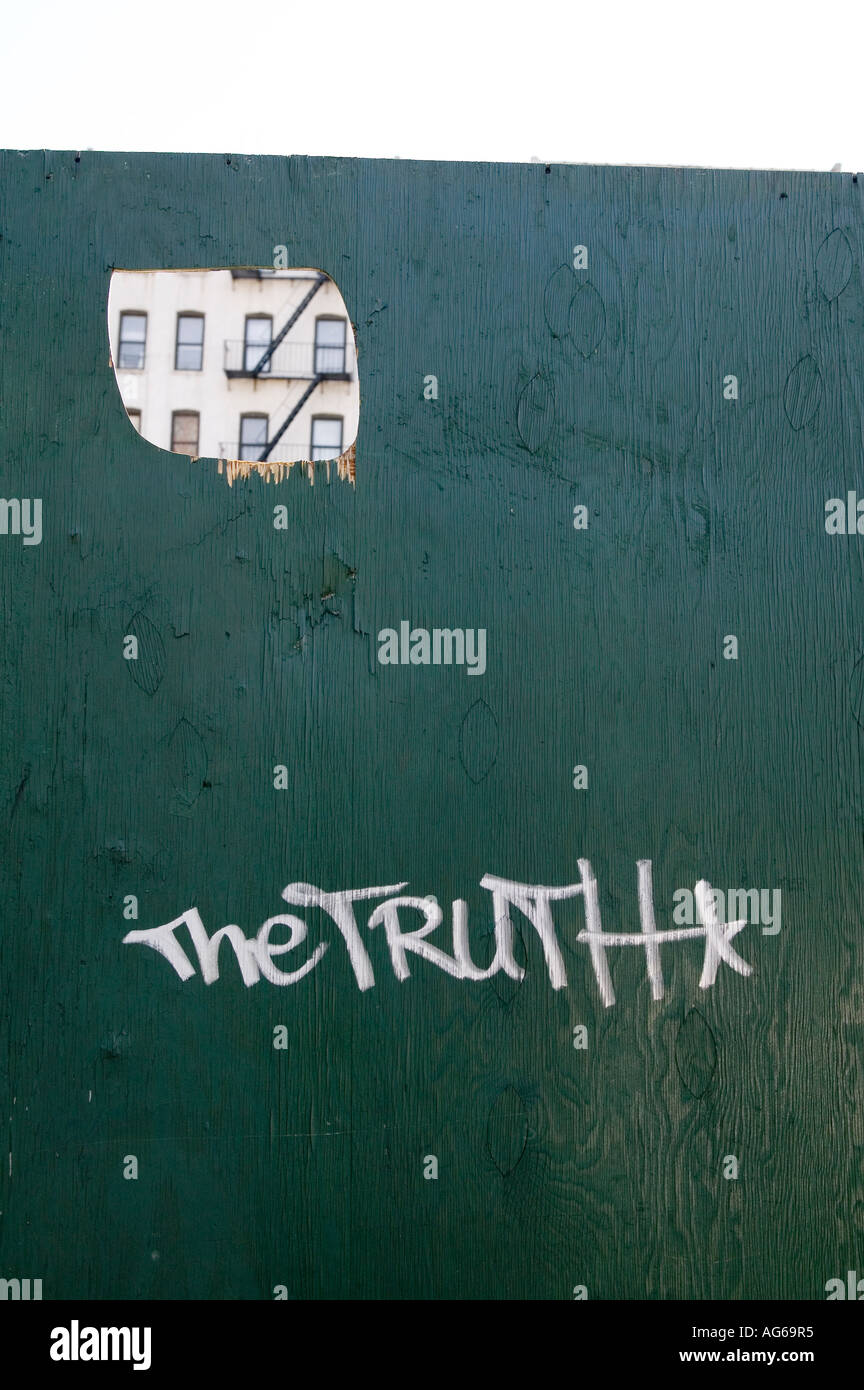 White The Truth graffiti on a green wooden wall with a hole by ...