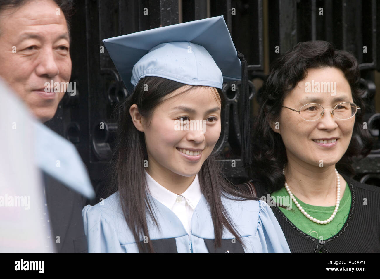 Female Asian Class Day graduate smiles and poses for photograph with ...