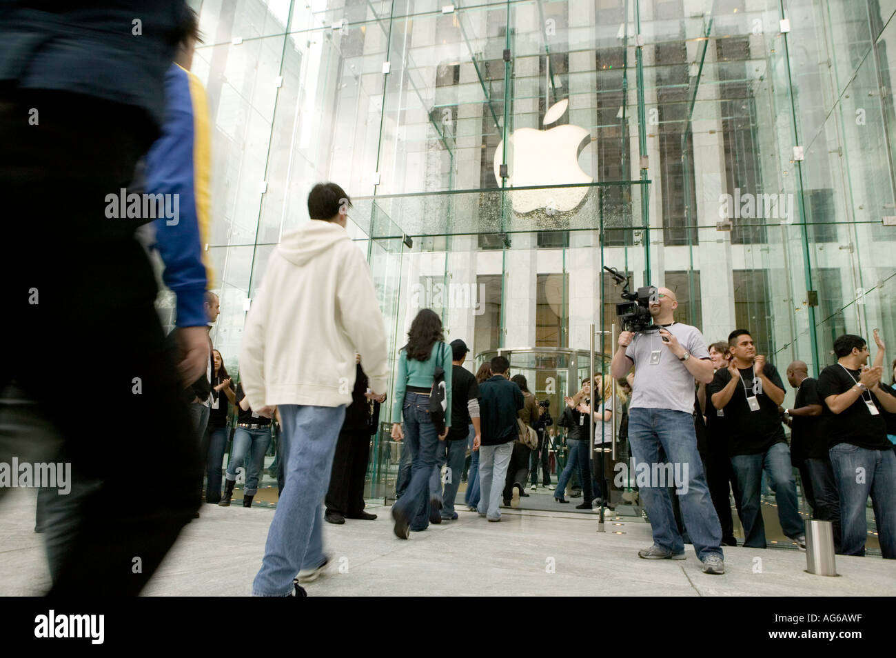 Apple employees cheer to welcome clients entering the Apple store cube ...