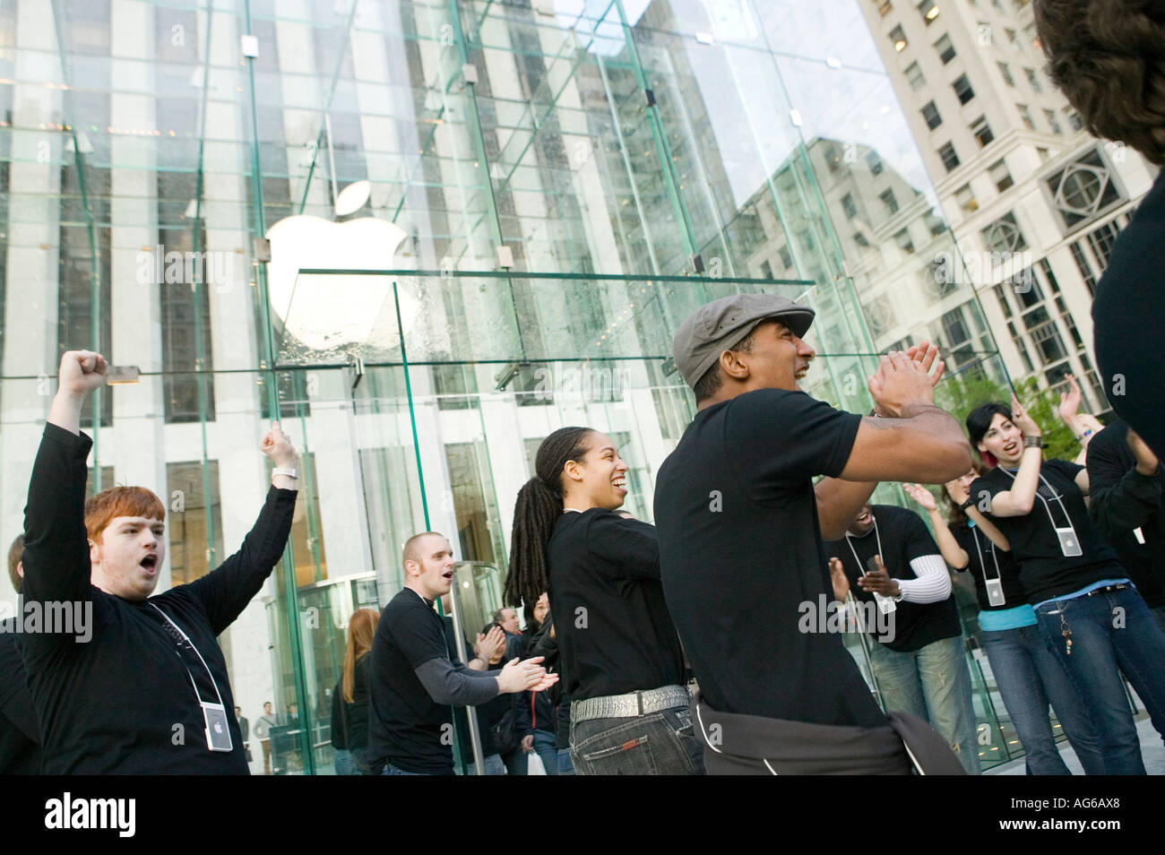 Apple employees cheer to welcome clients entering the Apple store cube ...