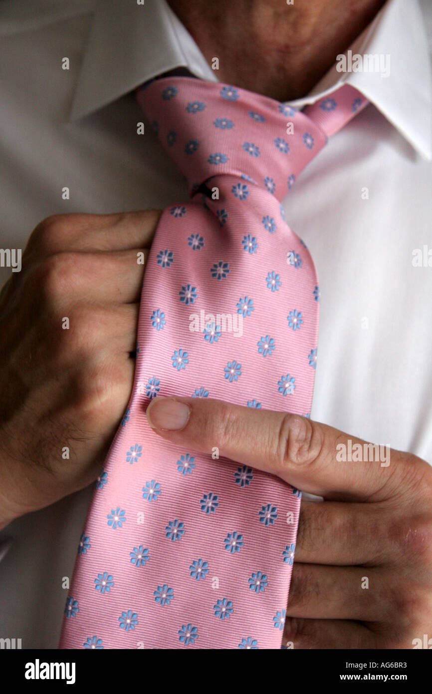 man tying knot with his necktie Stock Photo - Alamy