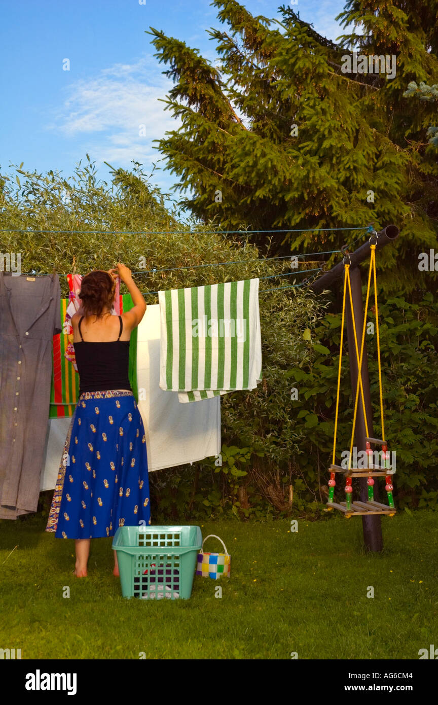 Young woman hanging clothes on a clothesline in the summertime Stock ...