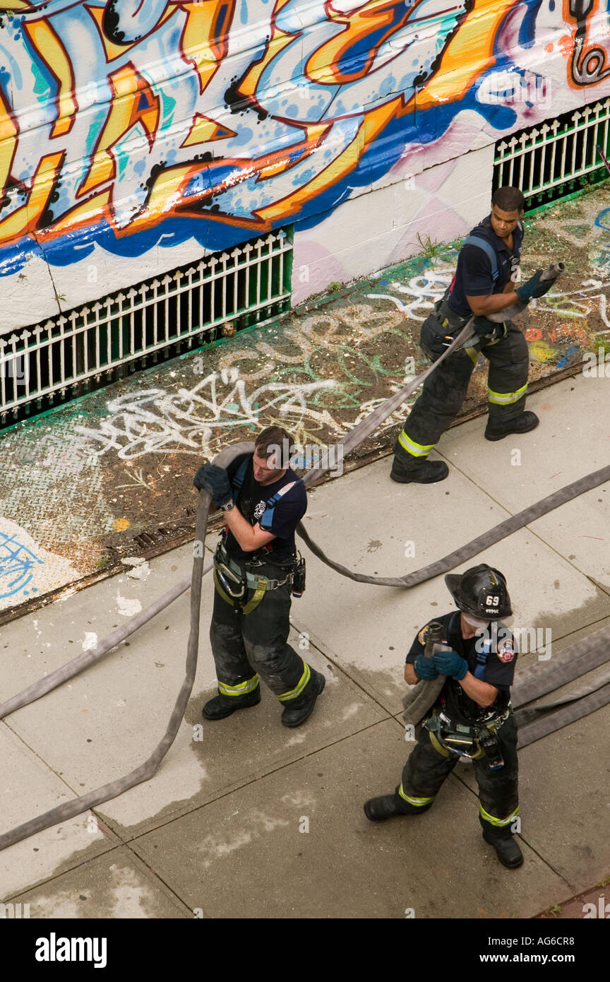 FDNY firemen put hoses away after an apartment building fire in Harlem ...