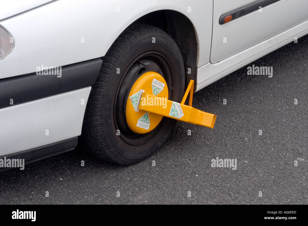 White car with DVLA wheel clamp and notice Stock Photo - Alamy