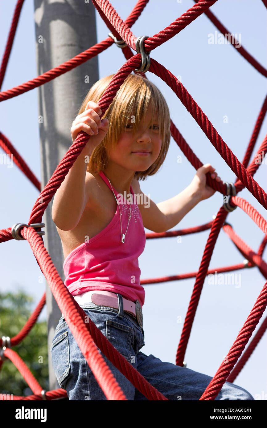 Young girl playing on a climbing frame in a playground Stock Photo - Alamy