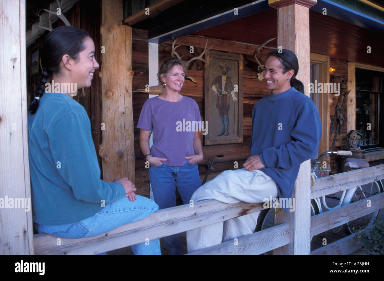 Friends Sitting And Smiling On A Cabin Porch Stock Photo - Alamy