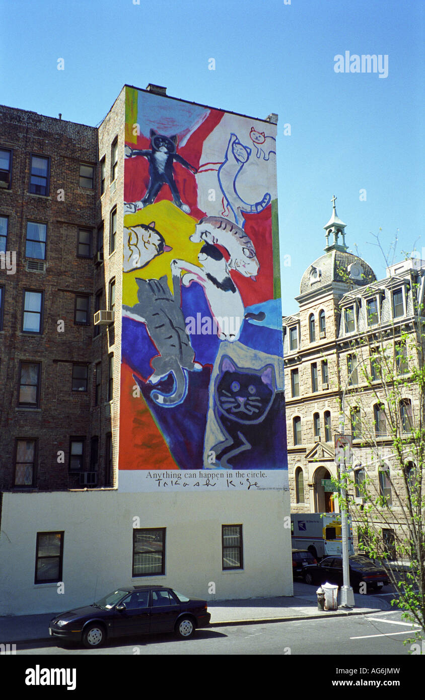 A building in a Manhattan street with a large mural of cats on the side ...