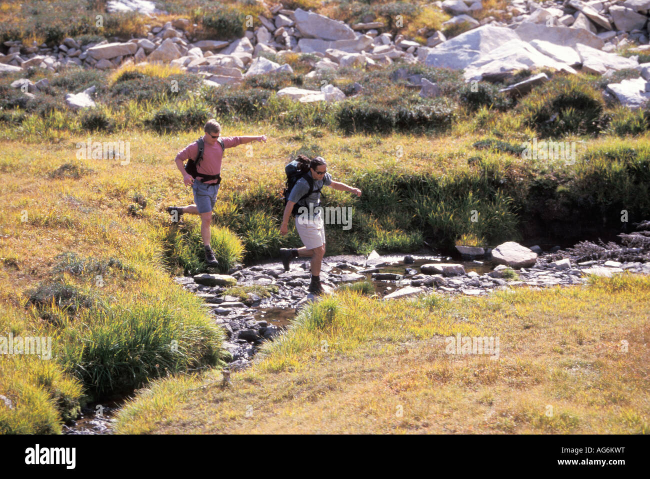 Hikers Crossing A Stream Stock Photo - Alamy