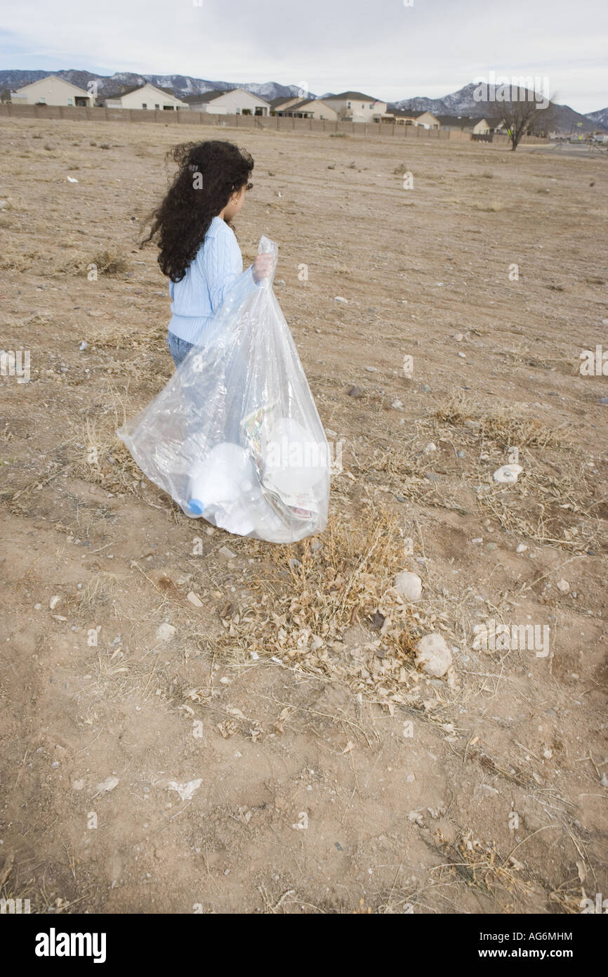 hispanic girl picking up trash in empty field, southwest usa Stock ...