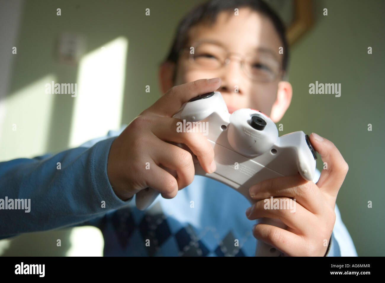ten year old asian boy using remote control game Stock Photo - Alamy