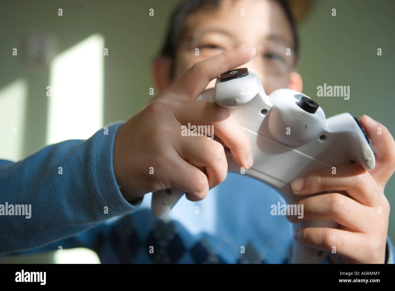 ten year old asian boy using remote control game Stock Photo - Alamy