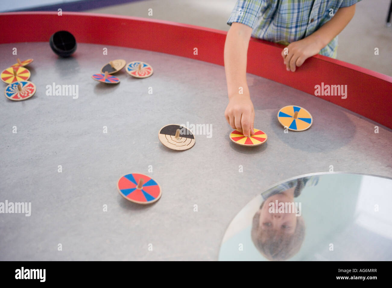 child spinning a variety of tops at Explora science museum, New Mexico ...