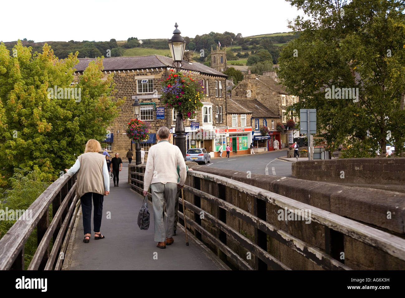 UK Yorkshire Nidderdale Pateley Bridge visitors crossing bridge over ...