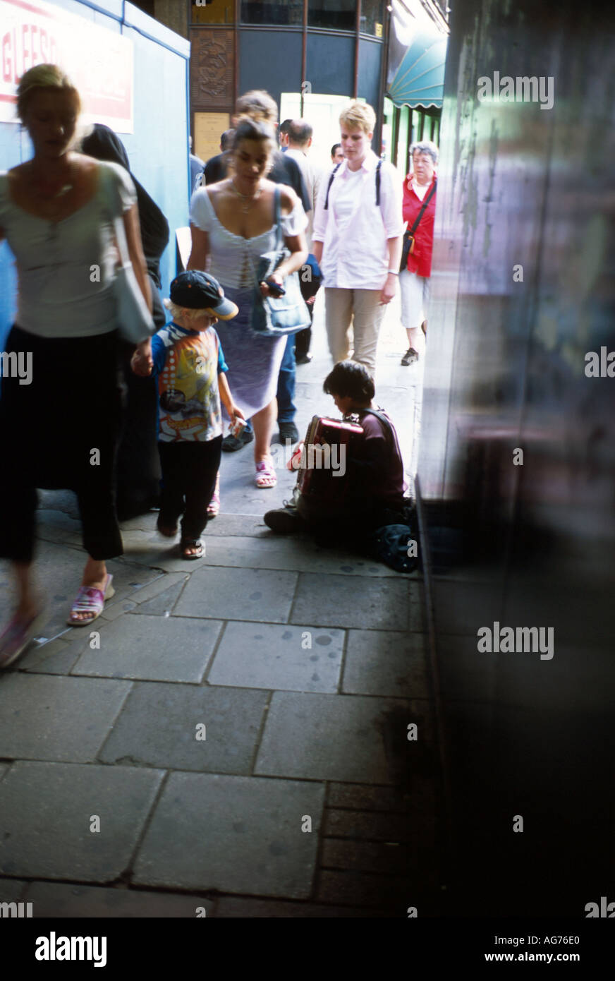 Homeless child playing accordion in the street of London, England ...