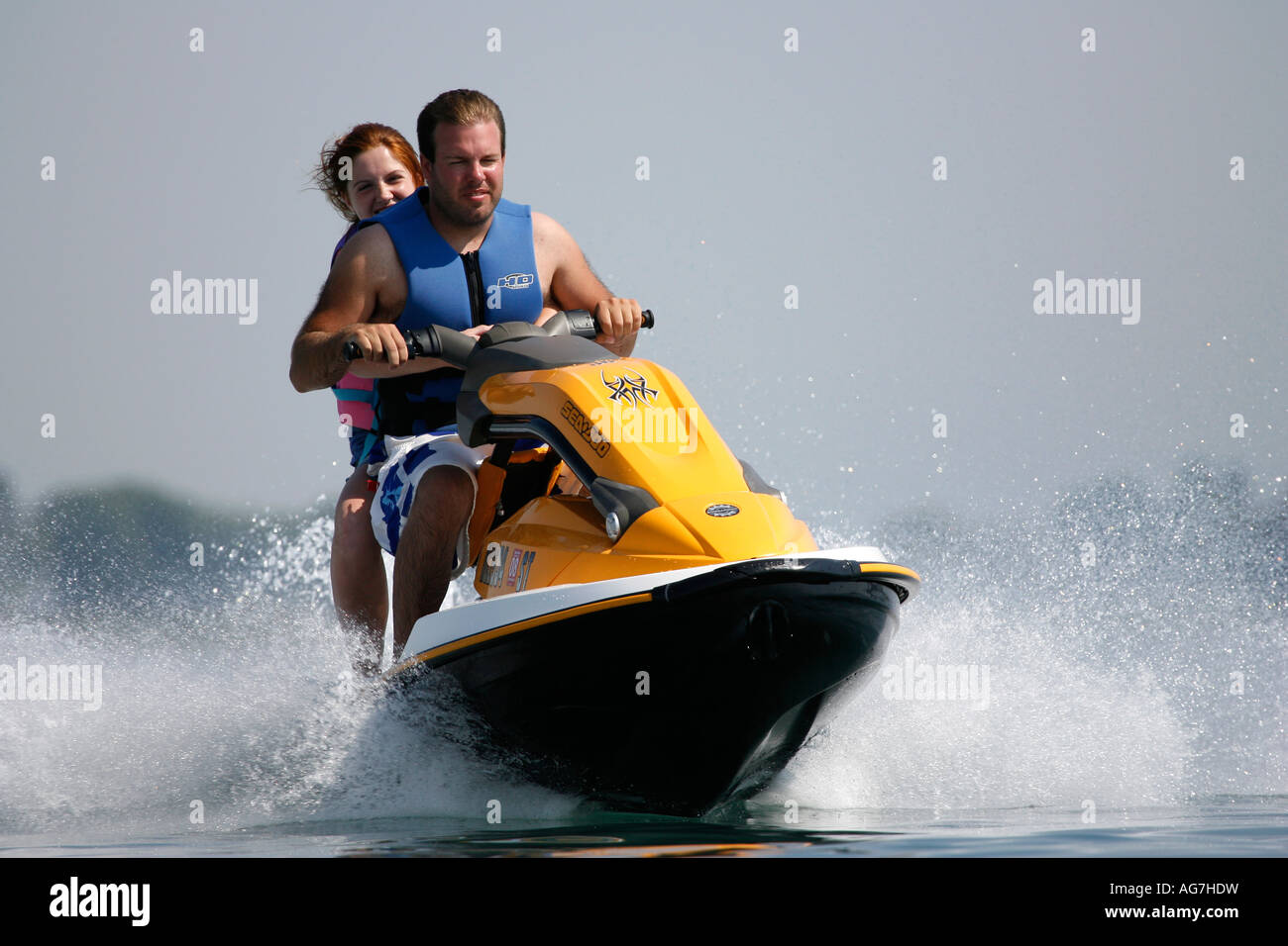 Man and girl riding a jet ski Stock Photo - Alamy