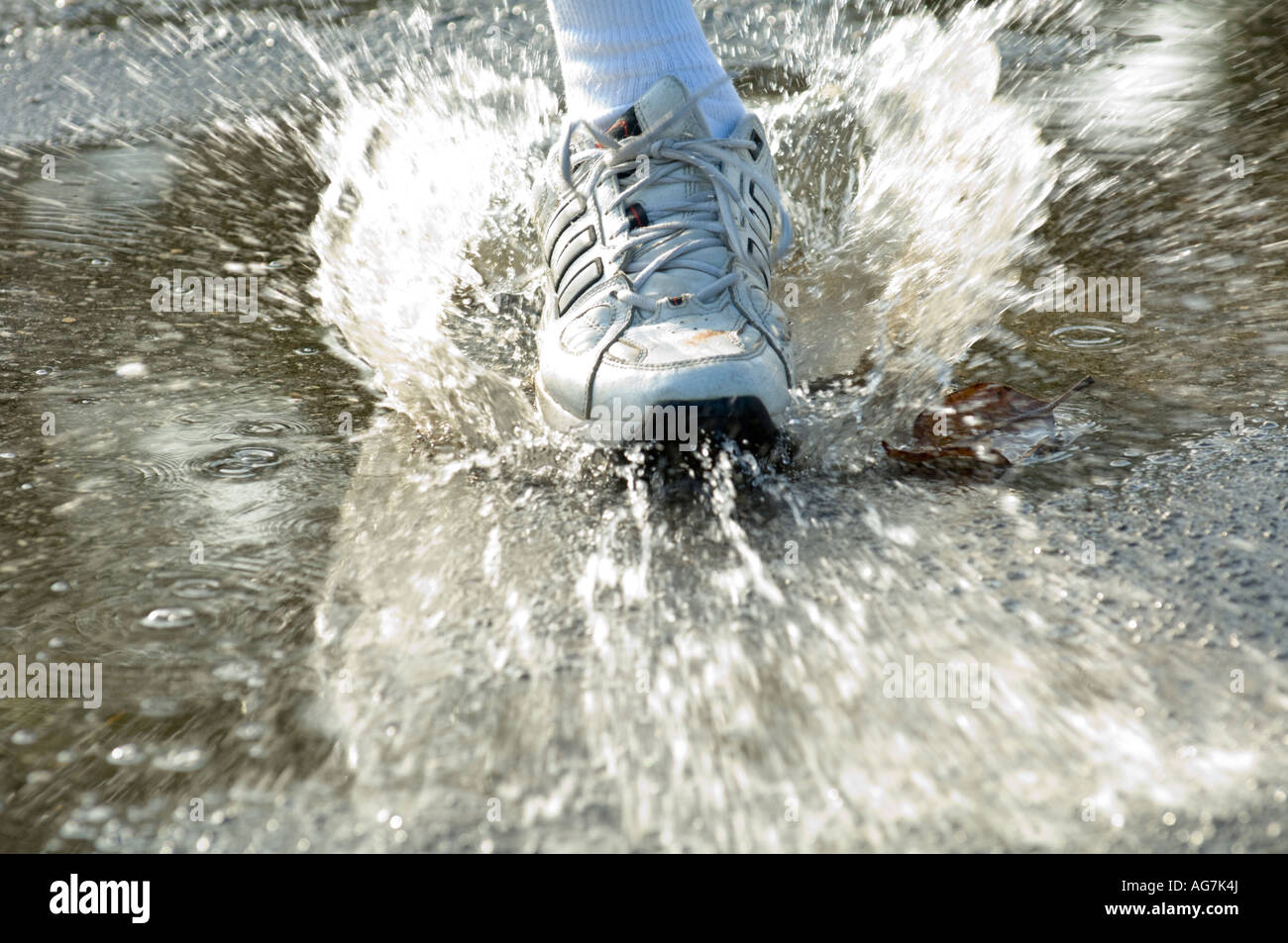 closeup running shoe hitting water puddle Stock Photo - Alamy