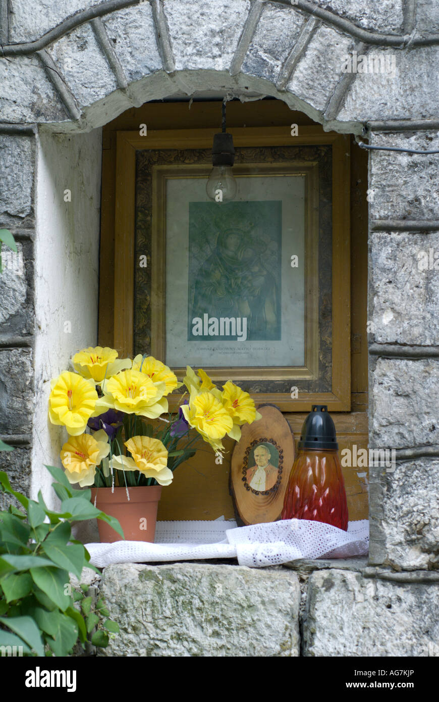 Detail of Catholic stone shrine in countryside with artificial flowers ...