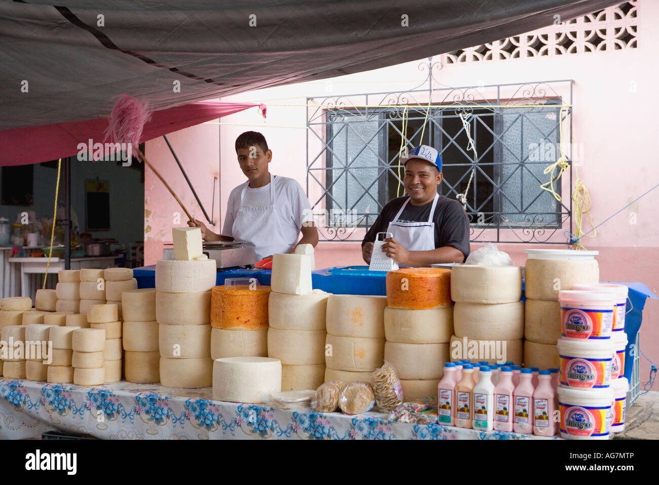 Cheese vendors stand arm in arm and show their goods at the market La ...