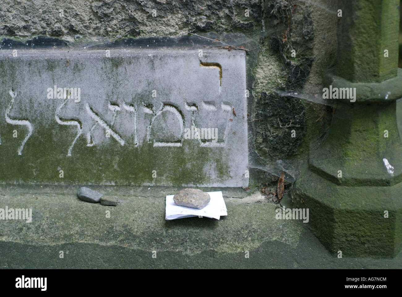 Folded paper note under a stone on Jewish tombstone, in ancient Jewish ...