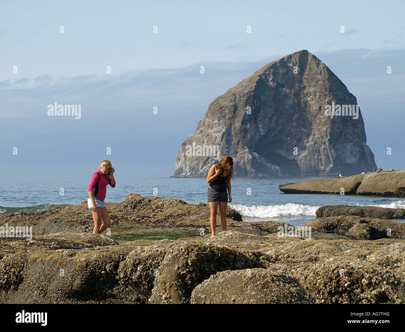 Two girls explore the tide pools on Cape Kiawanda in Pacific City ...