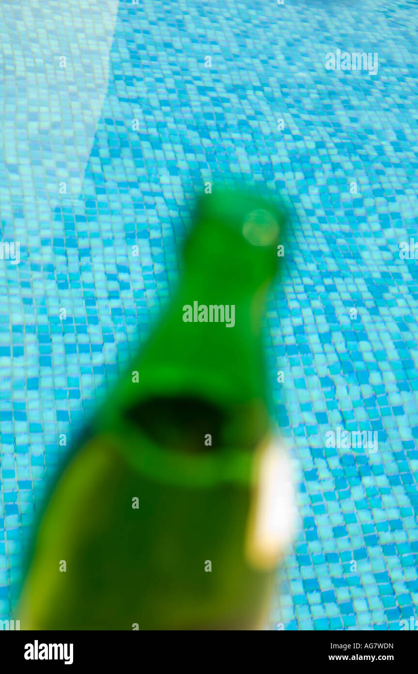 Bottle of beer sitting beside swimming pool Stock Photo - Alamy