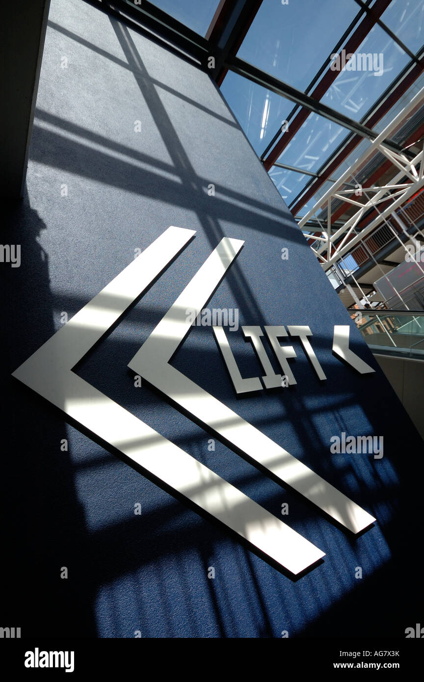 Large lift sign in car park with direction arrows and sunlight and ...