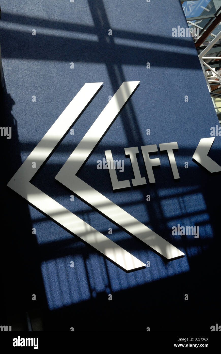 Large lift sign in car park with direction arrows and sunlight and ...