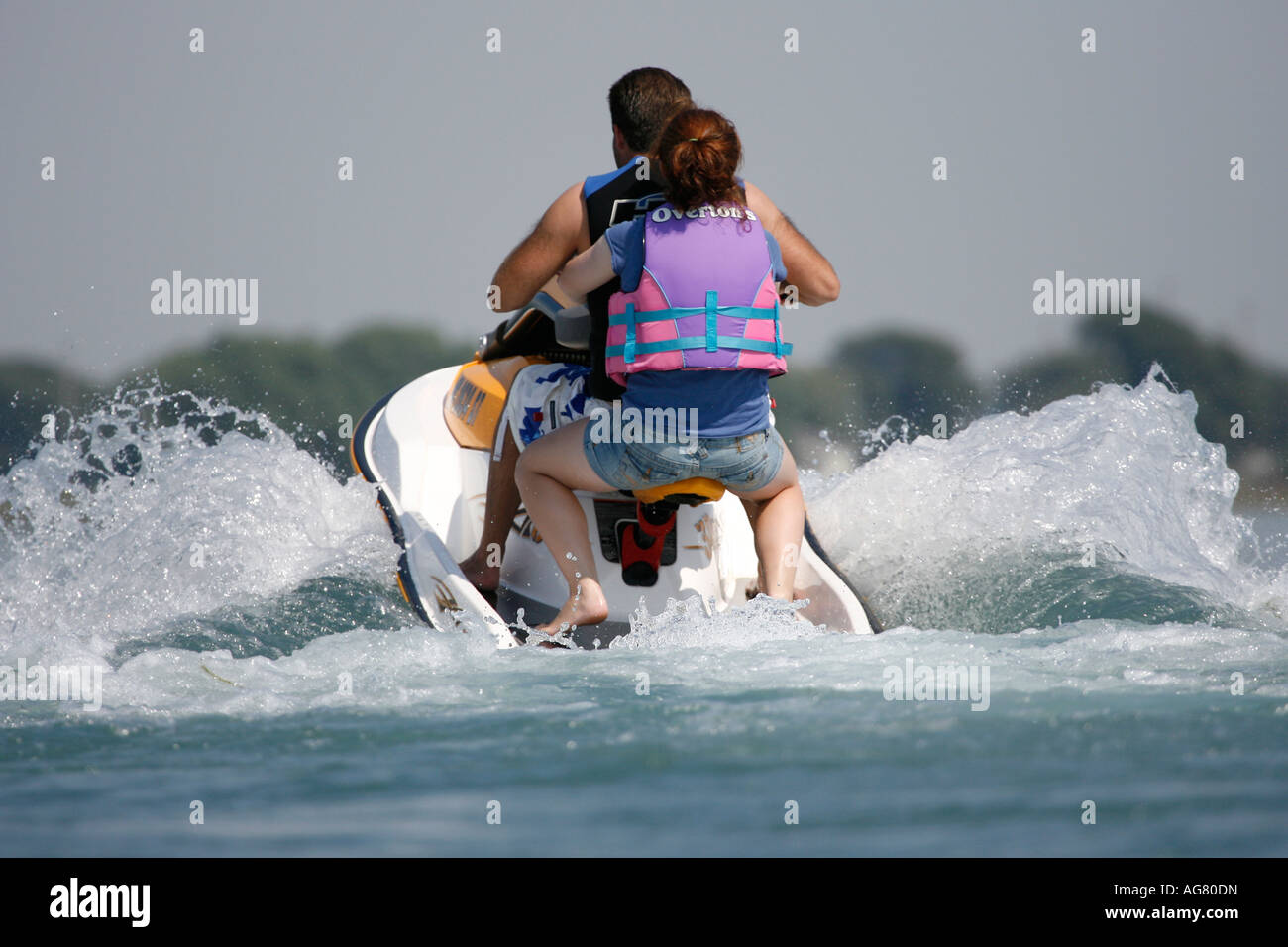 Two young people on a jet ski Stock Photo - Alamy