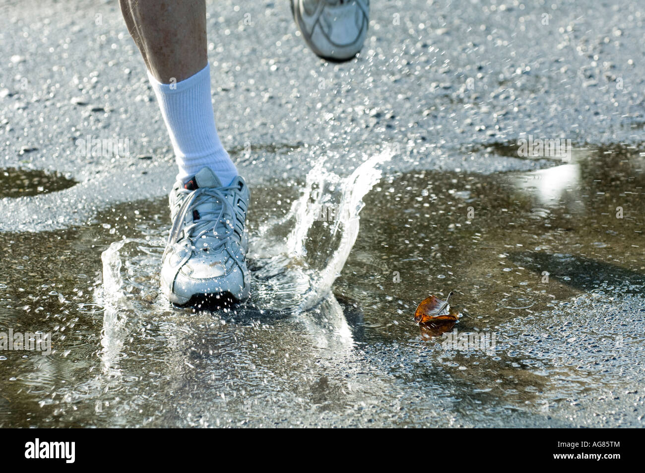 closeup running shoe hitting water puddle Stock Photo - Alamy