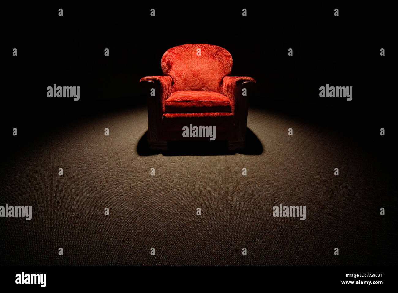 Armchair under a spotlight Stock Photo - Alamy