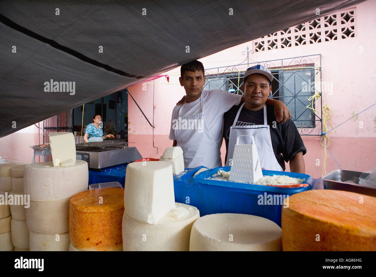 Cheese vendors stand arm in arm and show their goods at the market La ...