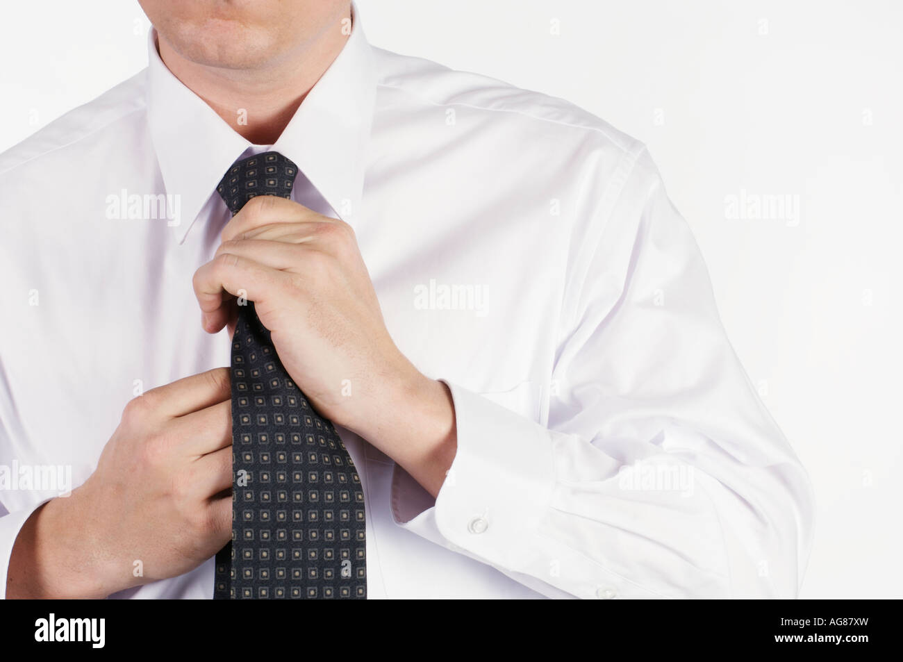 Businessman straighting tie Stock Photo - Alamy