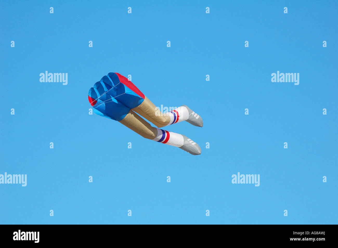 kite or balloon of lower half of a body flying alone against a blue sky ...