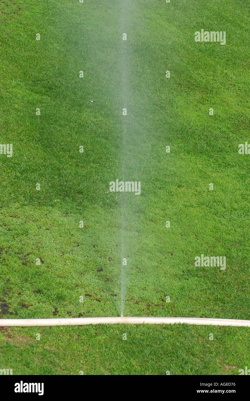 Water spraying out of a leak in a water hose Stock Photo - Alamy