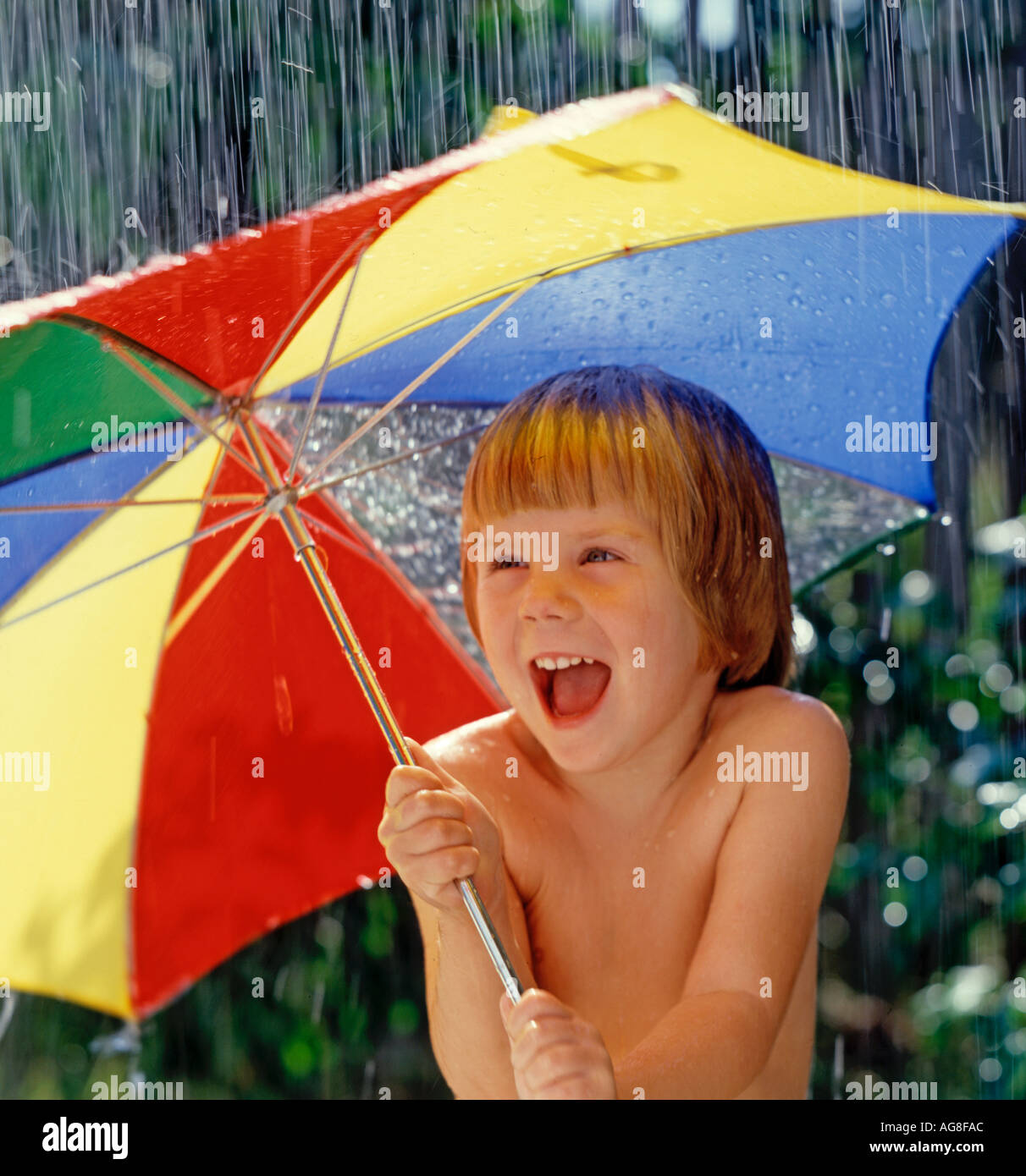 small girl playing in rain with umbrella Stock Photo - Alamy