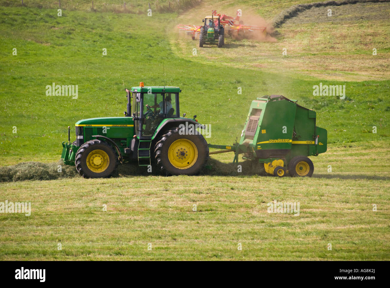 Harvest hay. Round baler in action Stock Photo - Alamy