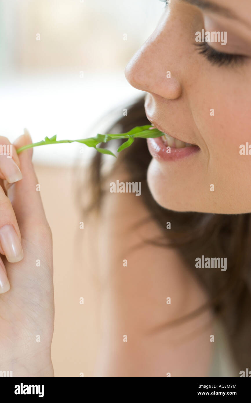 woman biting rocket leaf Stock Photo - Alamy