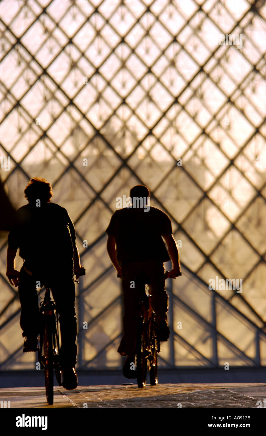 Louvre Pyramid & Men Cycling Stock Photo - Alamy