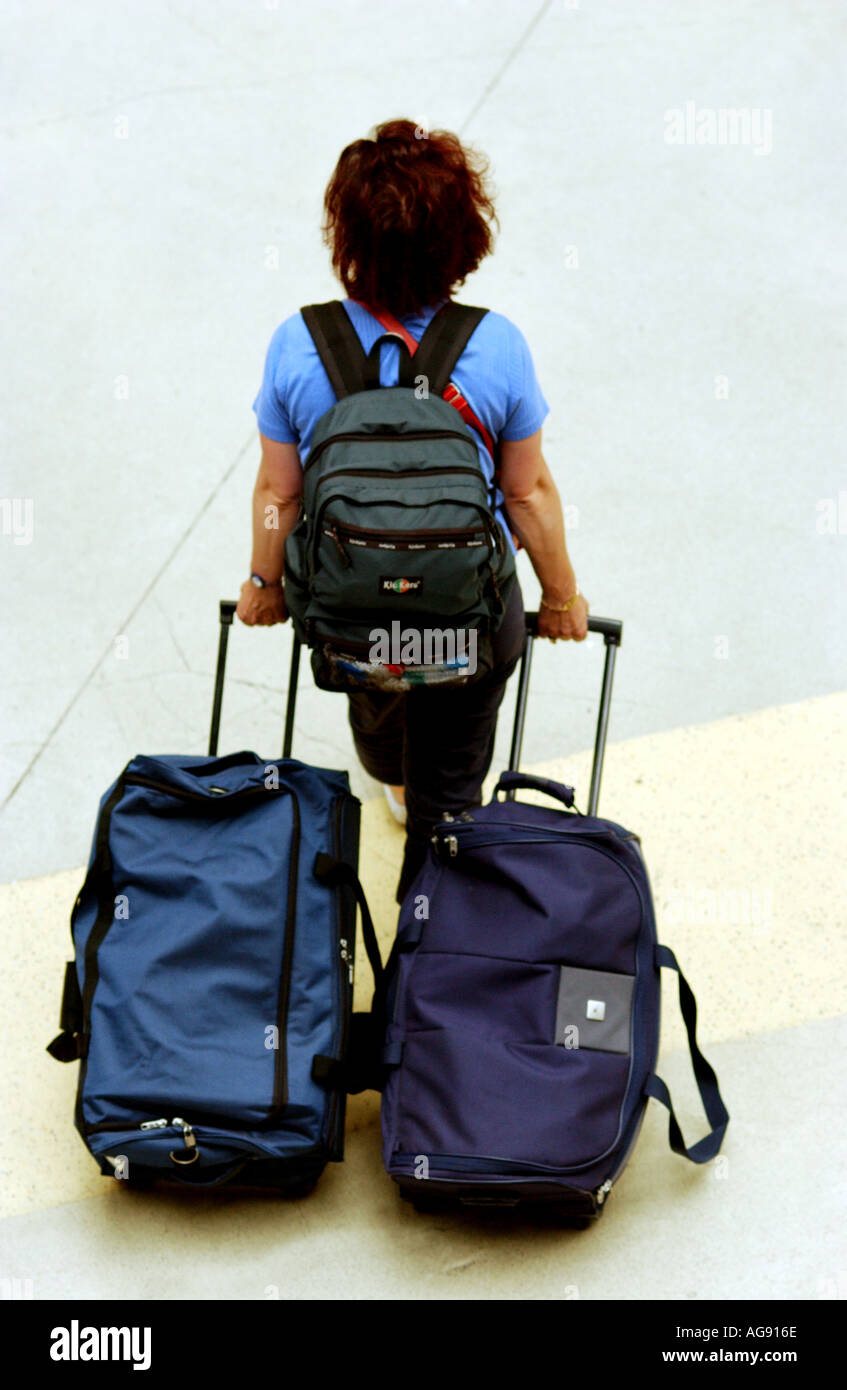 Woman pulling suitcases hi-res stock photography and images - Alamy